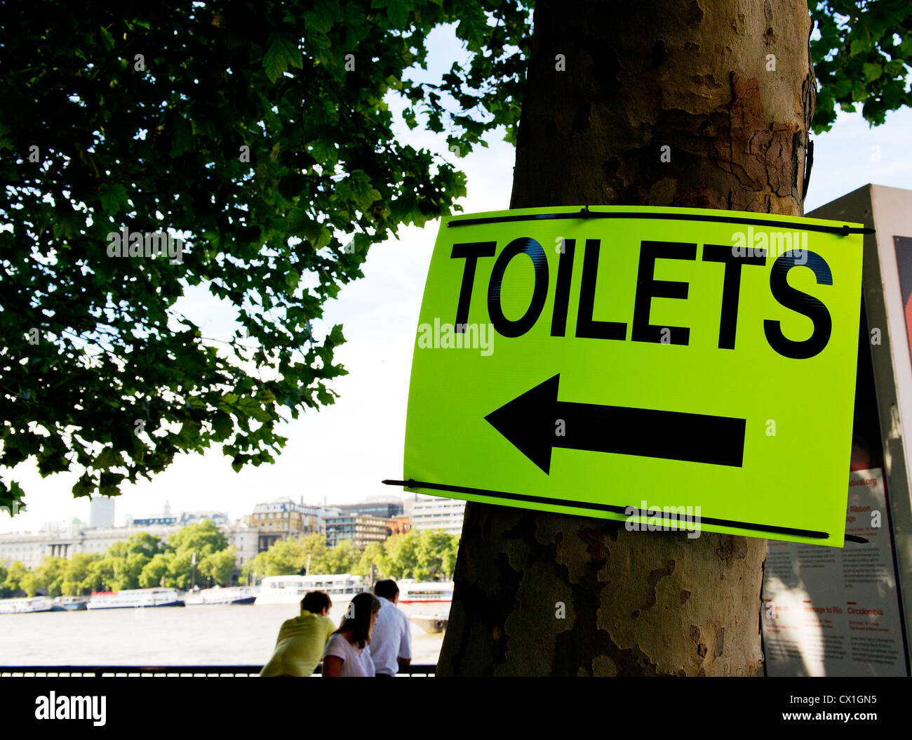 A sign for toilets pinned to a tree Stock Photo - Alamy