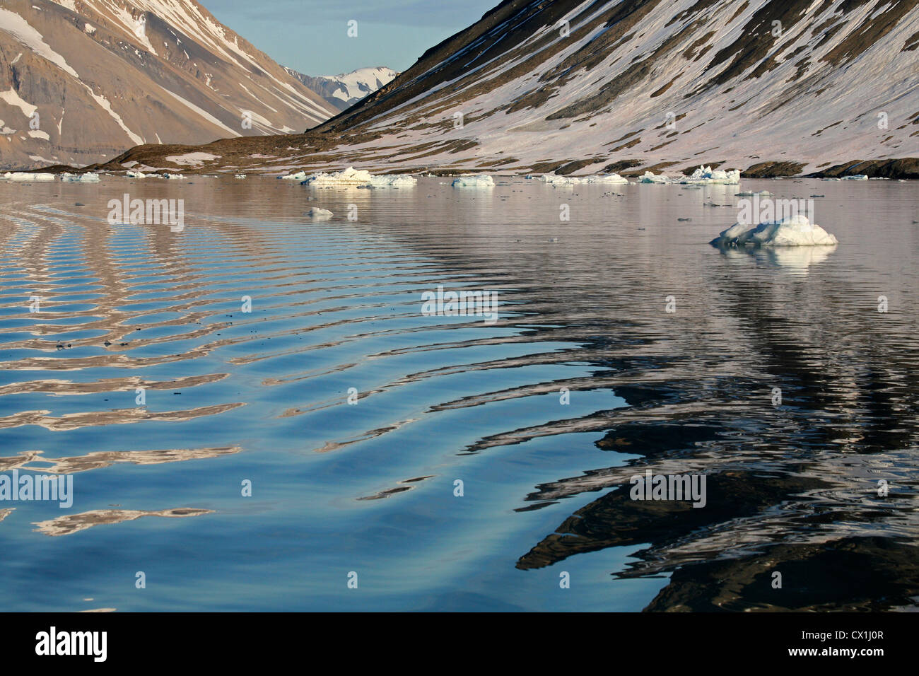 Water ripples in wake of sailing ship and view over mountains and sea ...