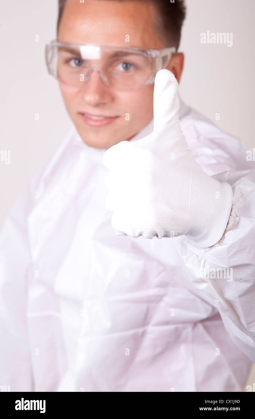 Portrait of a young attractive male laboratory technician showing thumb ...