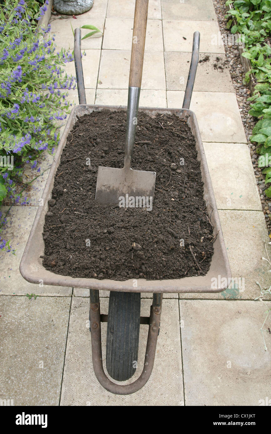 a wheelbarrow being used for garden work Stock Photo - Alamy