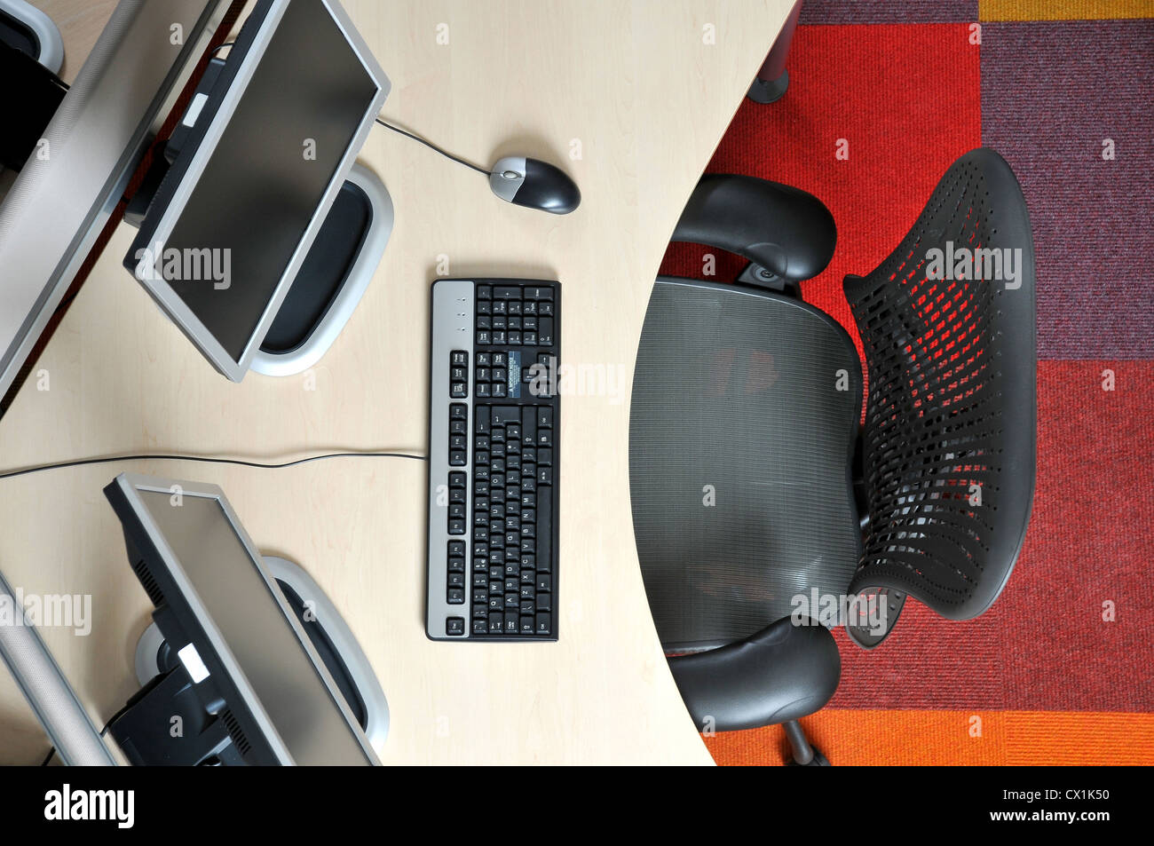 An office hot desk with computer screens keyboard and chair Stock Photo ...
