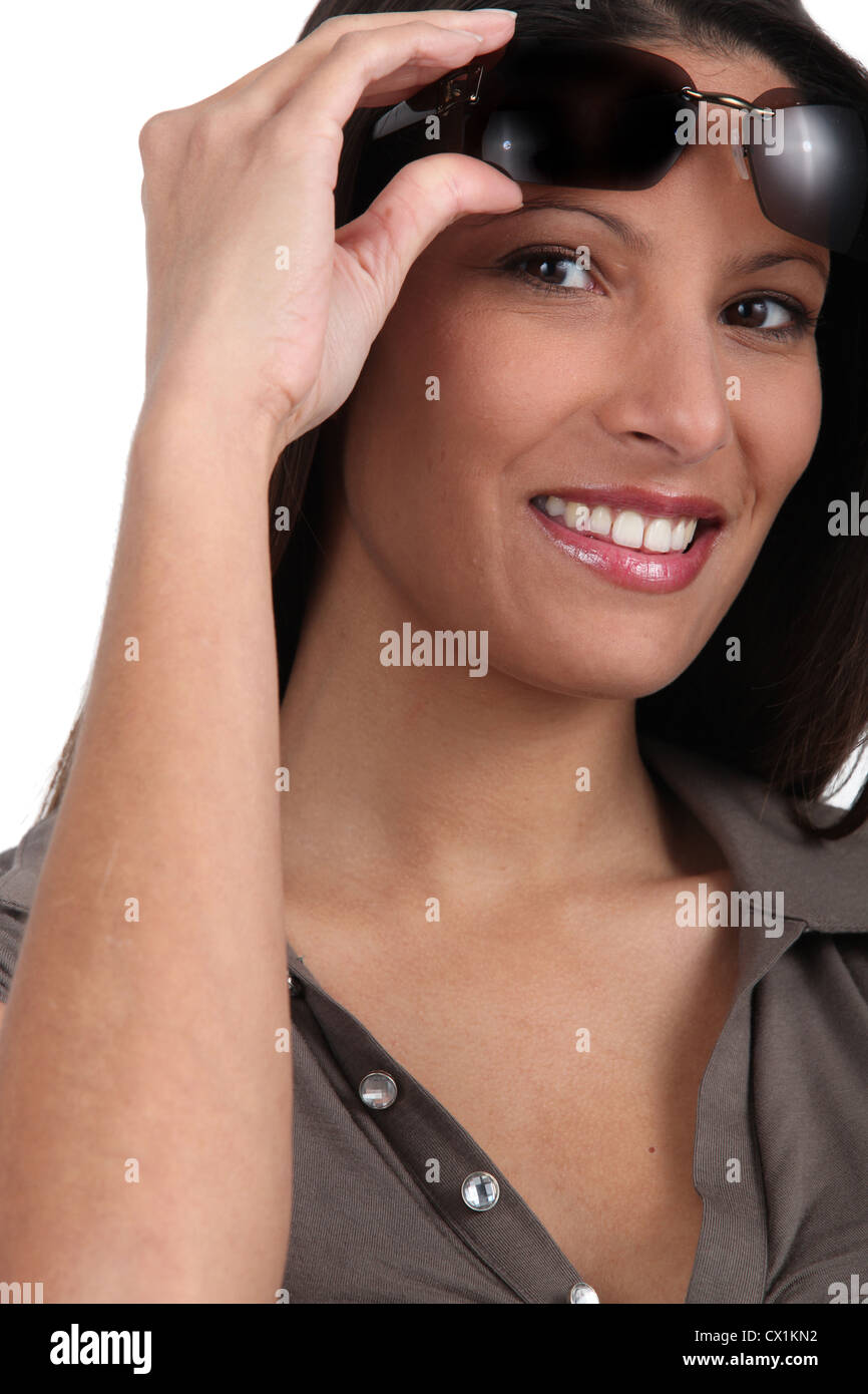 Brunette woman taking off her sunglasses Stock Photo - Alamy