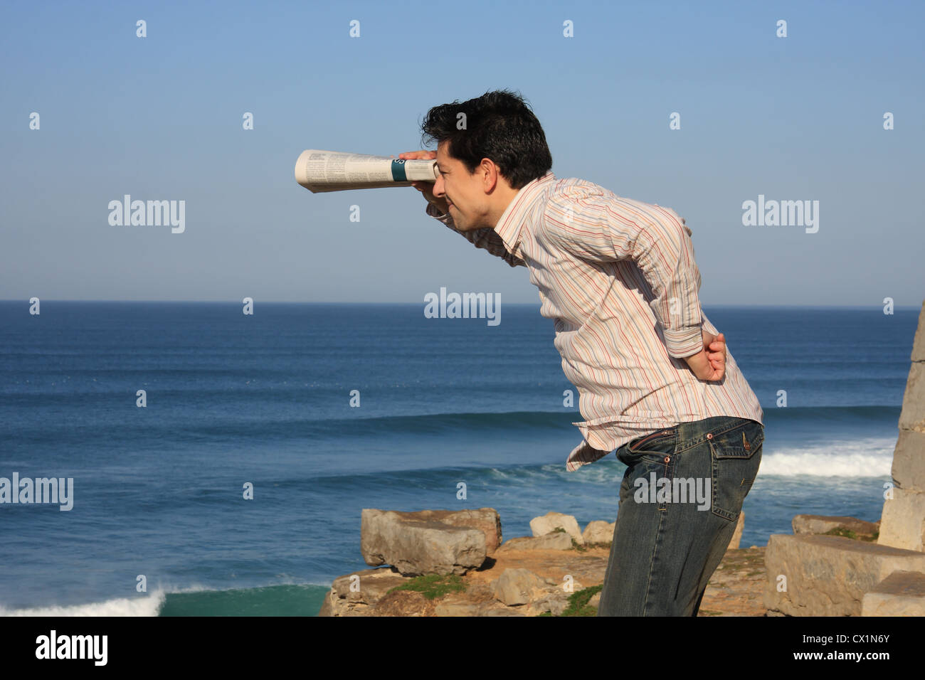Young man trying to see something with a newspaper binocular Stock ...