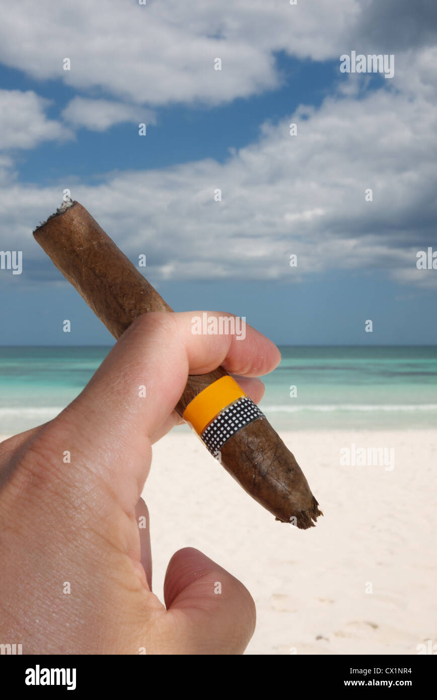 A lit cigar on the beach in Tulum Mexico Stock Photo - Alamy