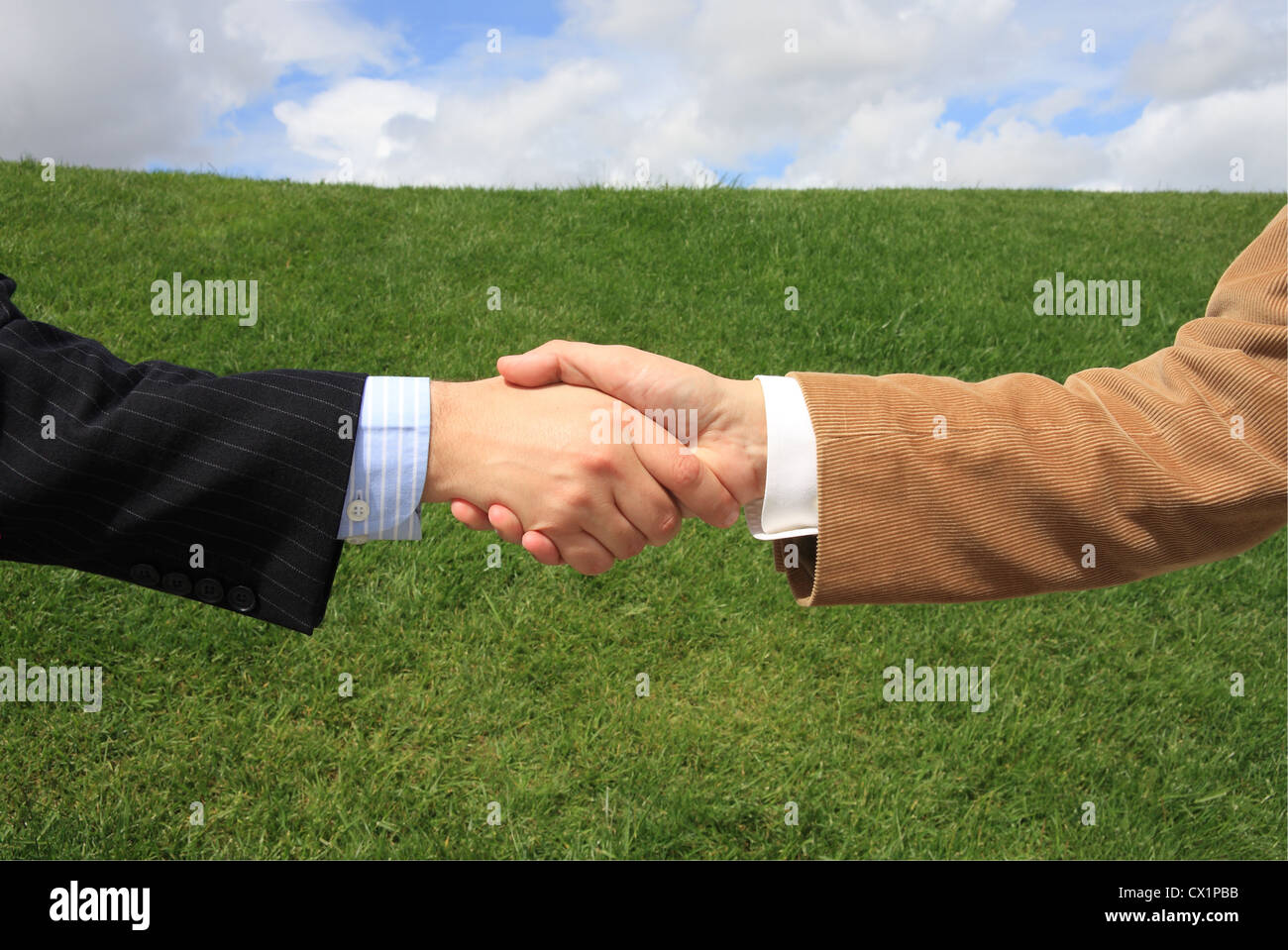 Two business men making a deal with a handshake at the field Stock ...