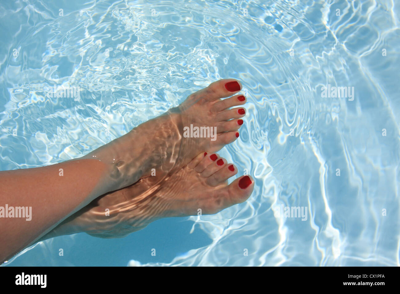 Relaxing woman with his foot on the water Stock Photo - Alamy