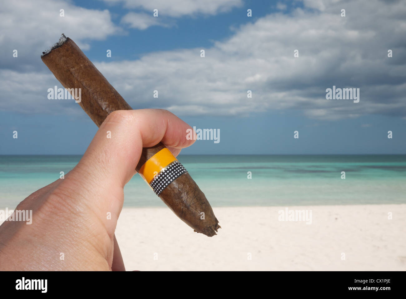 A lit cigar on the beach in Tulum Mexico Stock Photo - Alamy