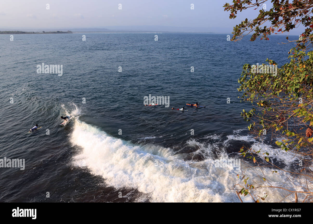 Surfers surfing the point break surf at Batu Karas in West Java Stock ...