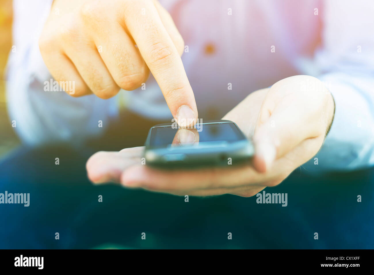 Man with smart phone on hand, blurred background Stock Photo - Alamy