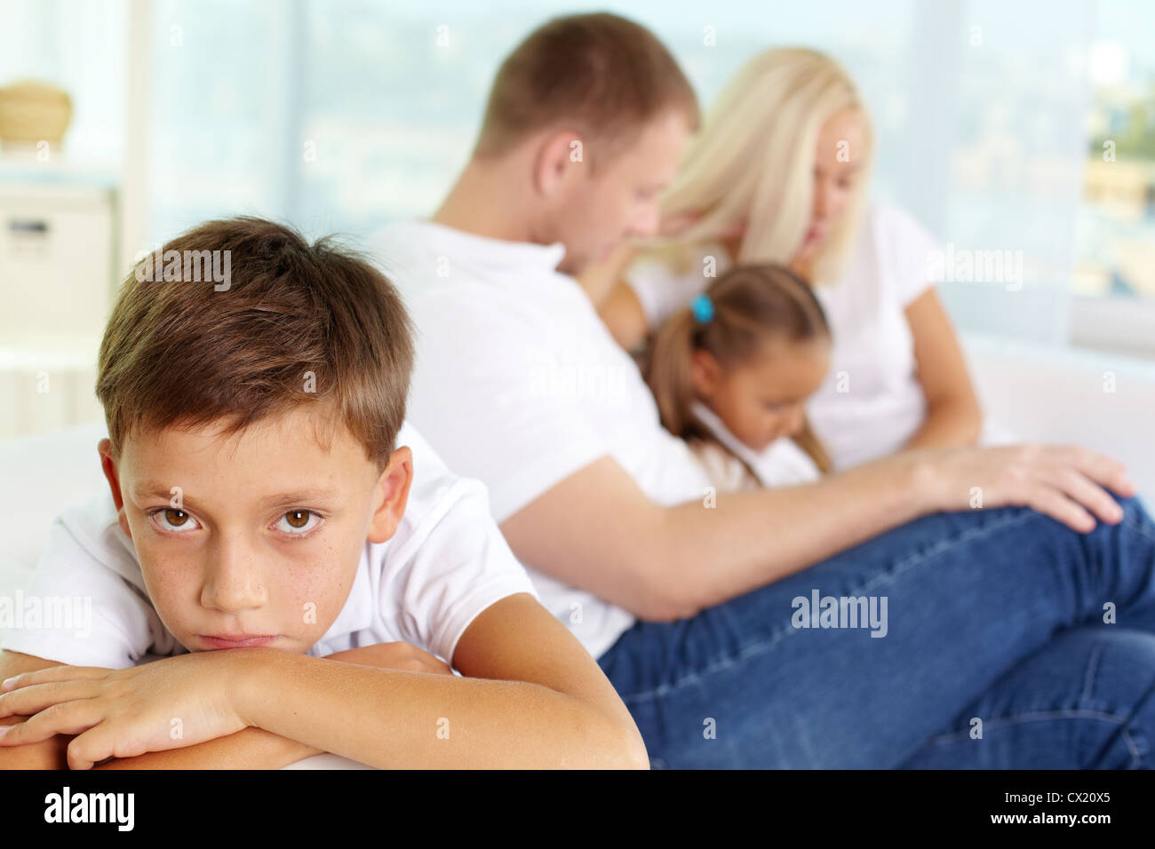Portrait of sad boy on background of his parents and sister Stock Photo ...