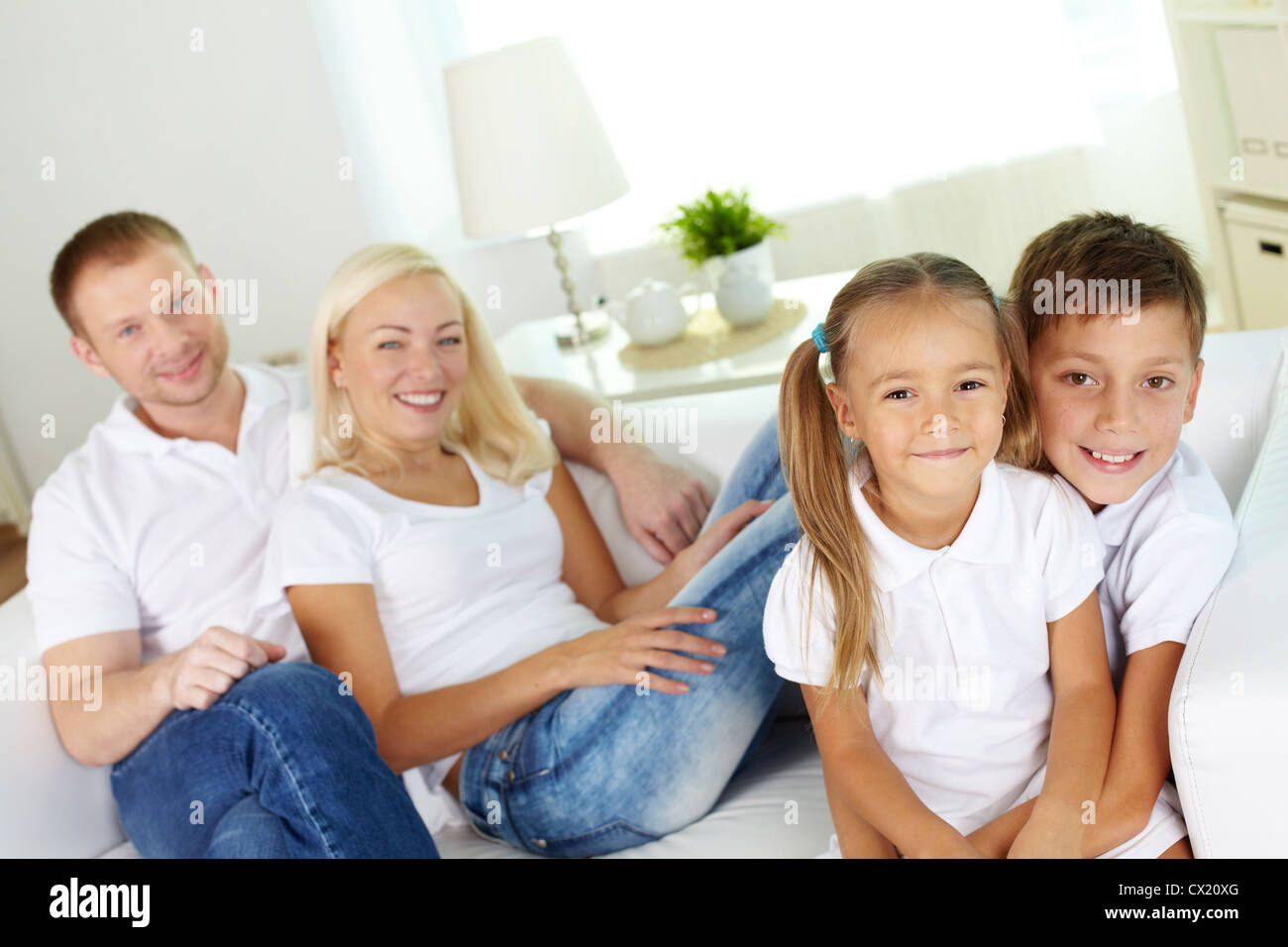 Portrait of happy children looking at camera with parents sitting ...