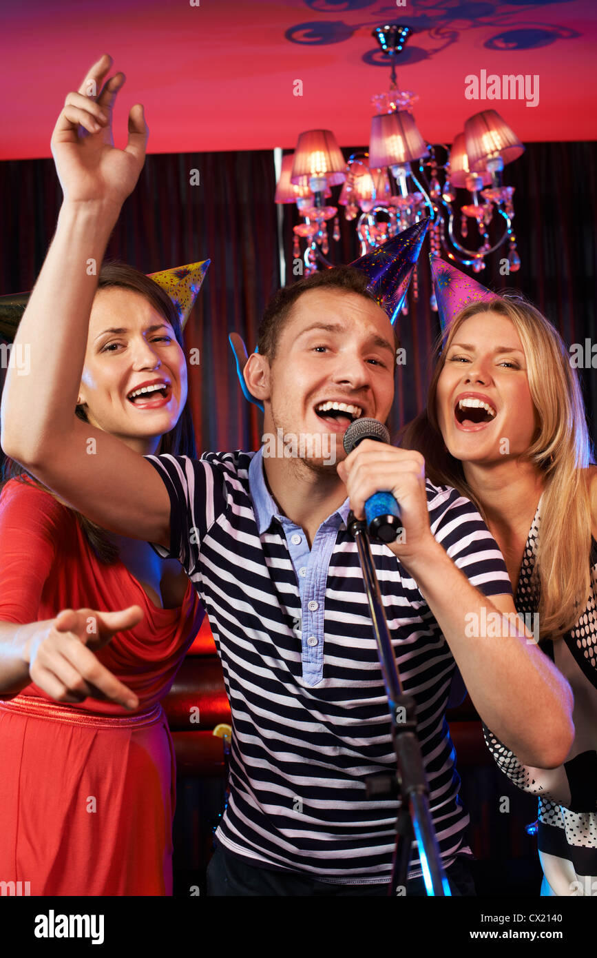 Portrait of happy people singing in microphone in the karaoke bar Stock ...