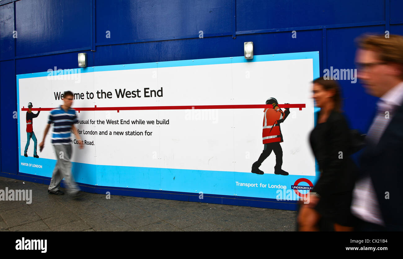 Pedestrian in London streets, passing a large poster Stock Photo - Alamy