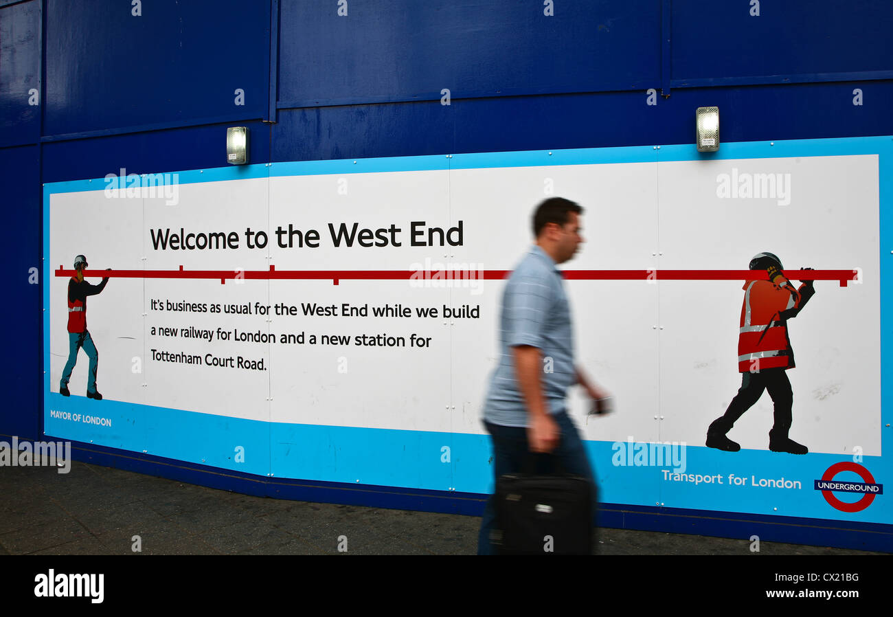 Pedestrian in London streets, passing a large poster Stock Photo - Alamy