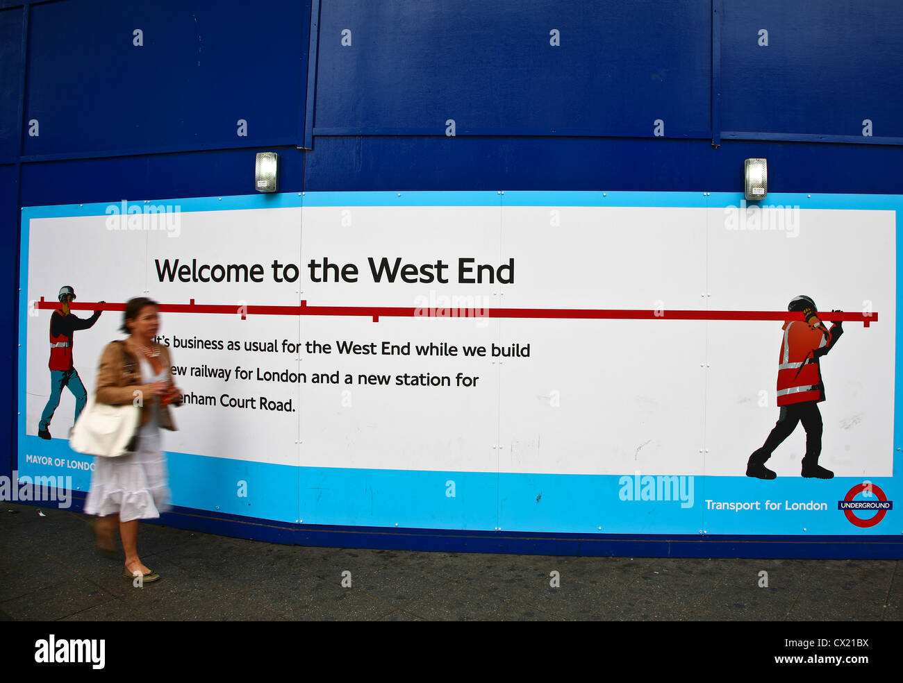 Pedestrian in London streets, passing a large poster Stock Photo - Alamy