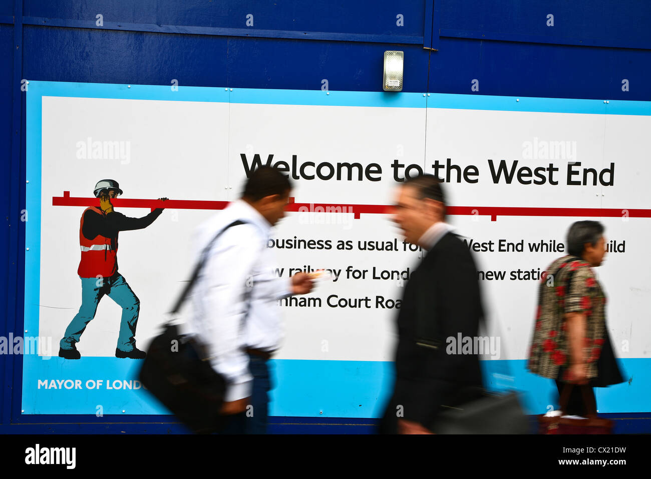 Pedestrian in London streets, passing a large poster Stock Photo - Alamy