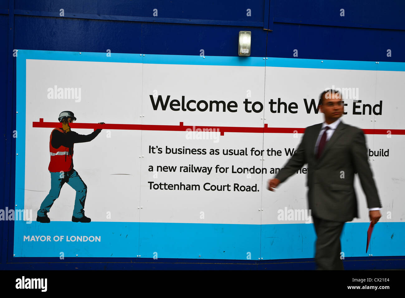Pedestrian in London streets, passing a large poster Stock Photo - Alamy