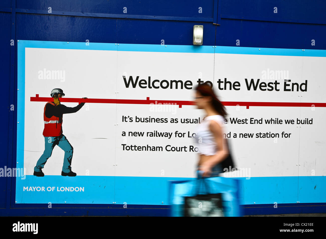 Pedestrian in London streets, passing a large poster Stock Photo - Alamy