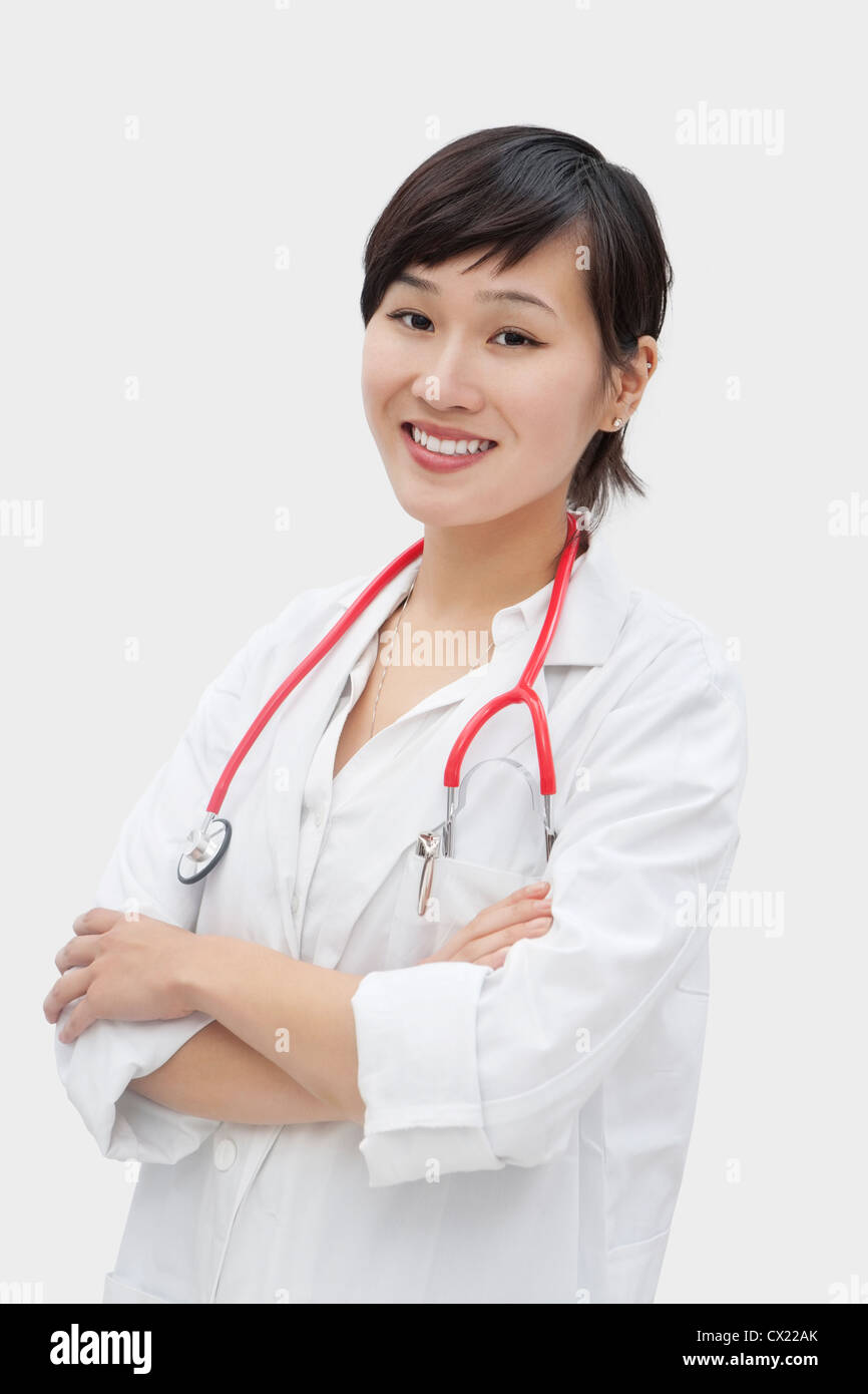Portrait of an Asian female veterinarian standing arms crossed over ...