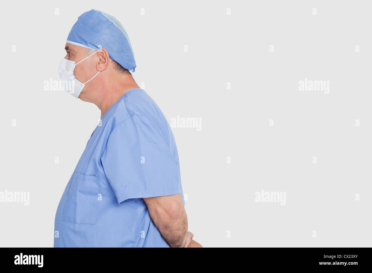 Profile shot of senior male surgeon standing with hands behind back ...