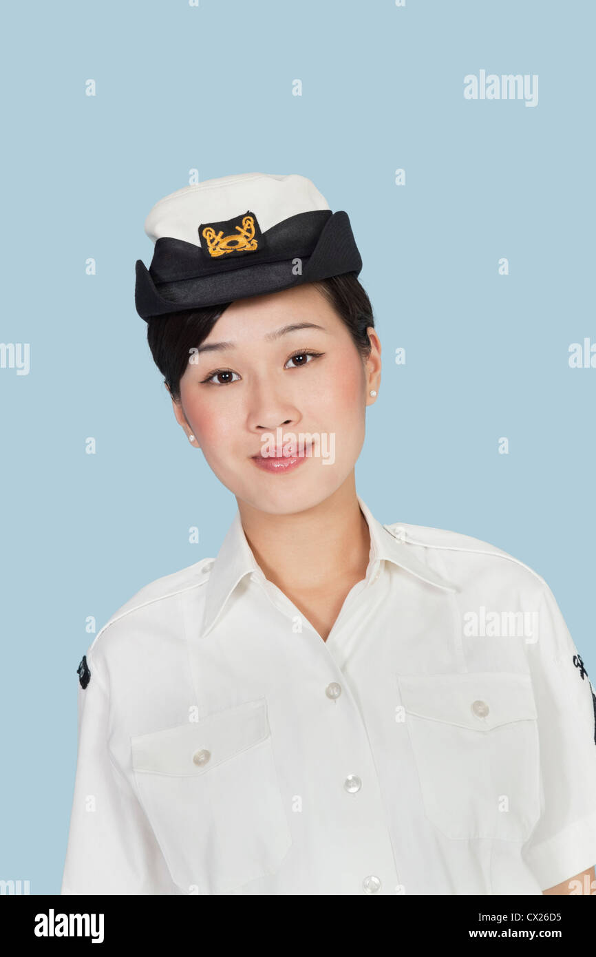 Portrait of a beautiful young US Navy officer over light blue ...