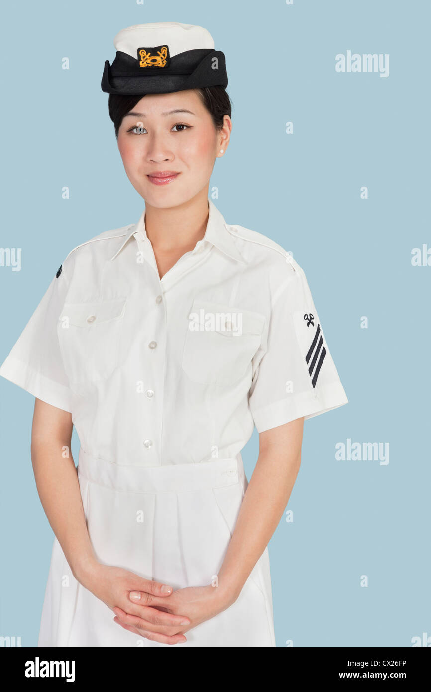 Portrait of a young female US Navy officer standing with hands clasped ...
