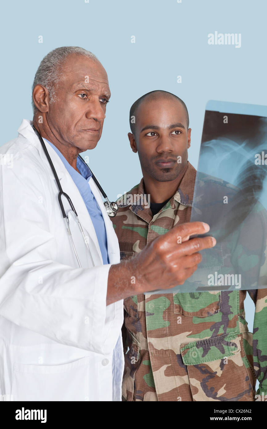 Senior doctor with US Marine Corps soldier looking at x-ray report over ...