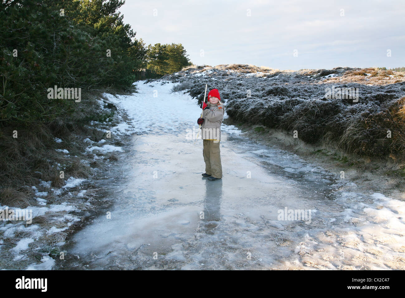 Boy on frozen puddle Stock Photo - Alamy