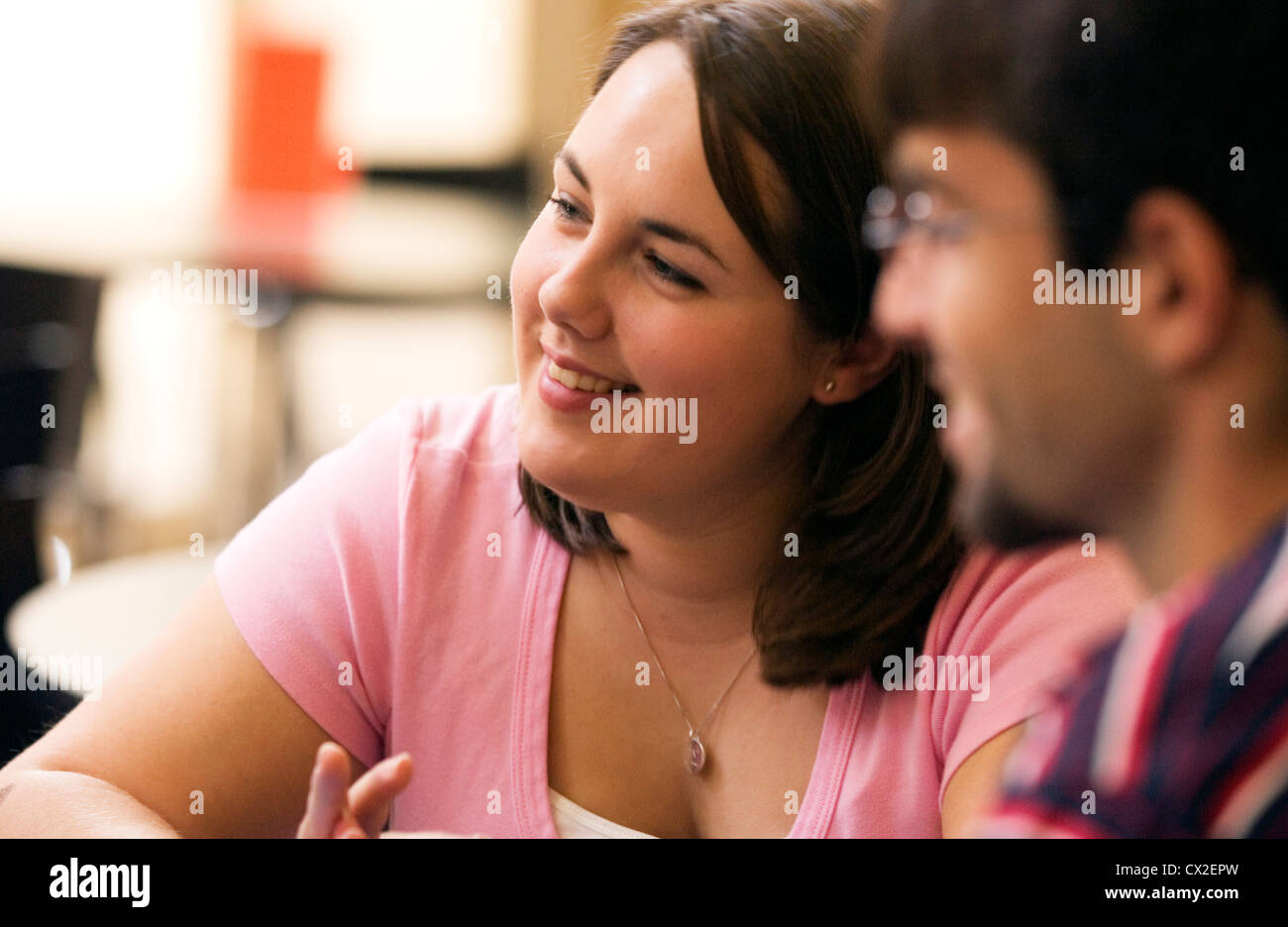 Male and female students smile in a classroom during a college class ...