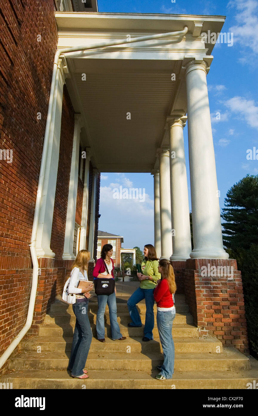 Four female students meet between classes on the steps of a college ...