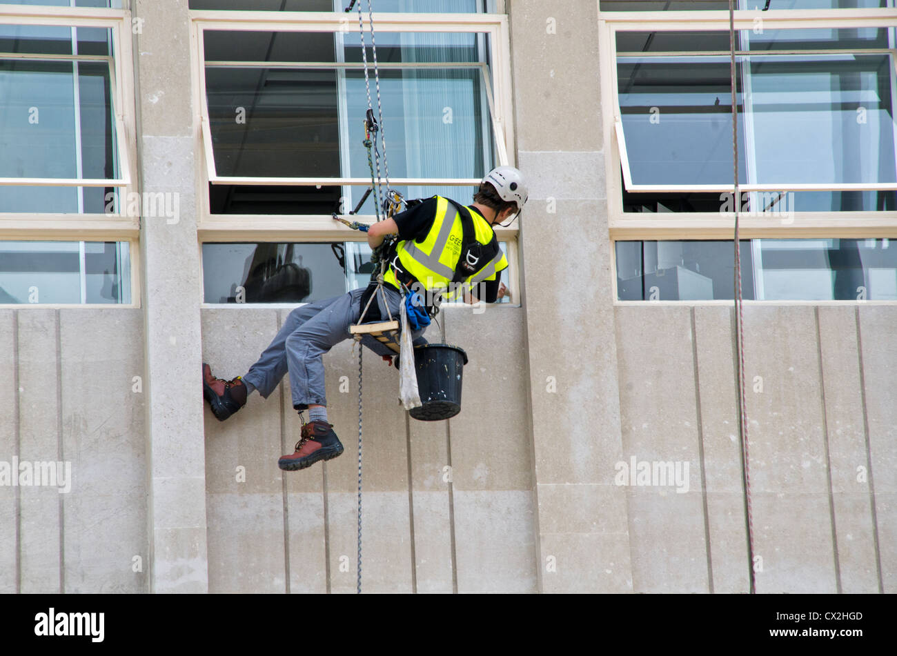 A lABORER HANGING ON THE WALL REPAIRING THE BUILDINGS WALL Stock Photo ...