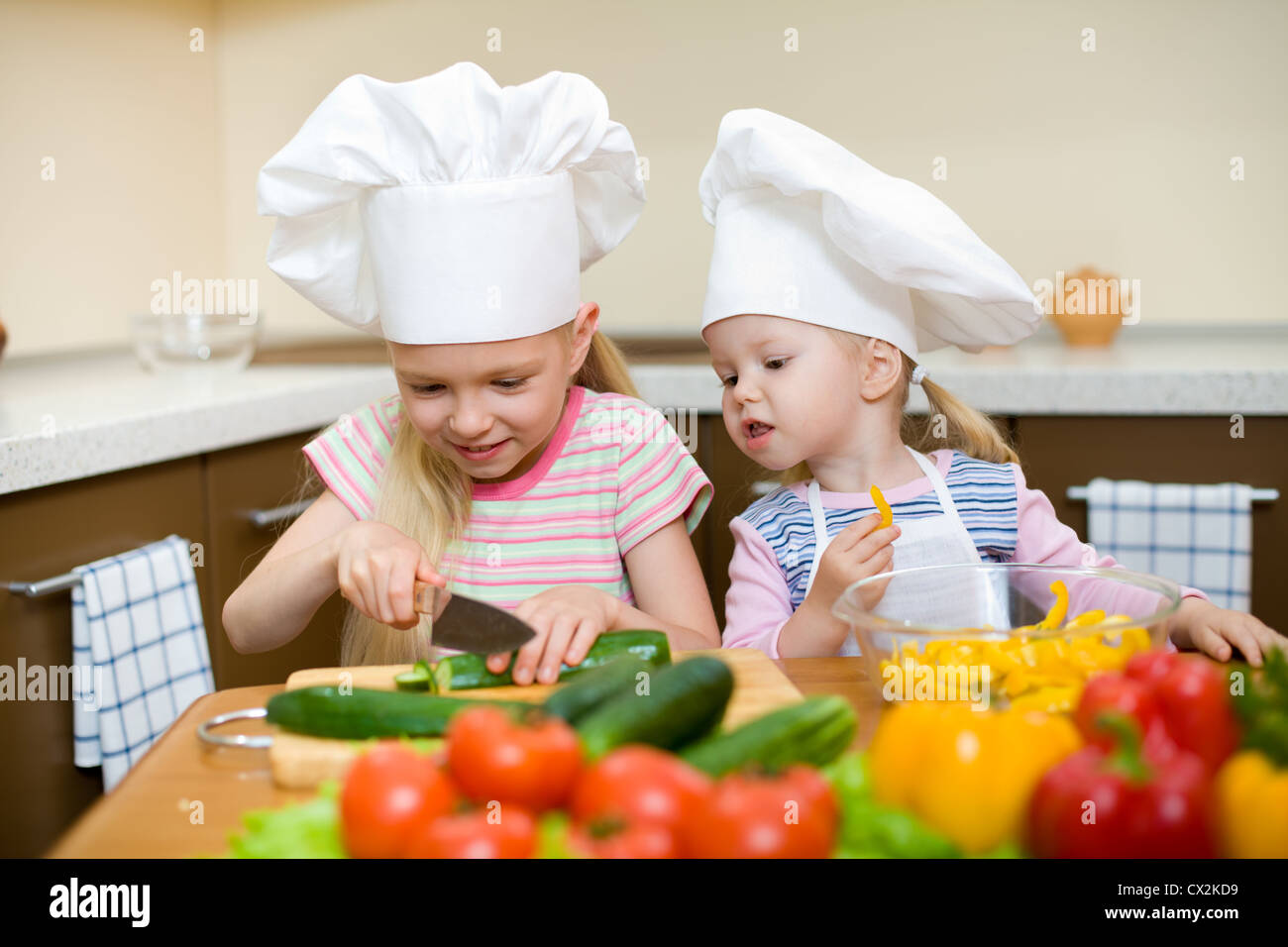 two little girls preparing healthy food on kitchen Stock Photo - Alamy