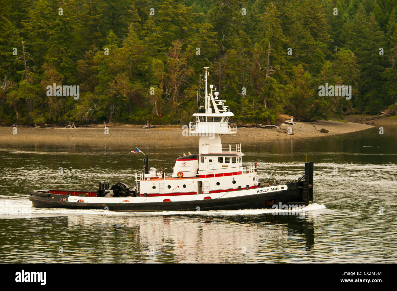 Tug boat Holly Ann navigating along the shoreline of the Puget Sound ...