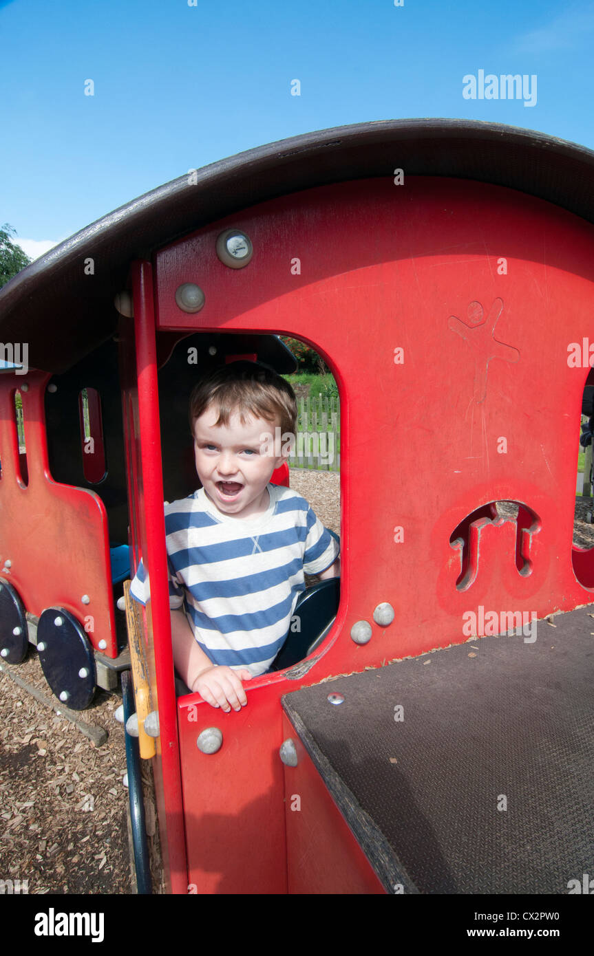 Boy playing on model train in play area Stock Photo - Alamy
