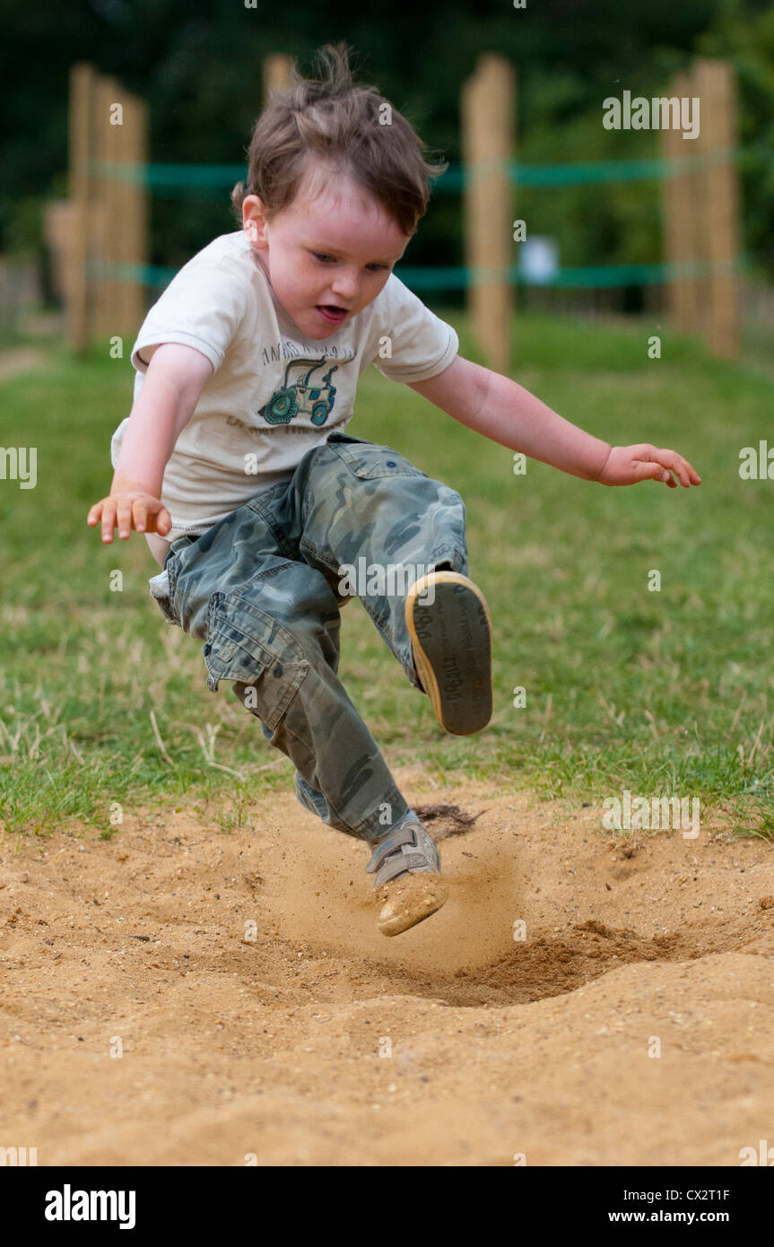 Young boy doing long jump Stock Photo - Alamy