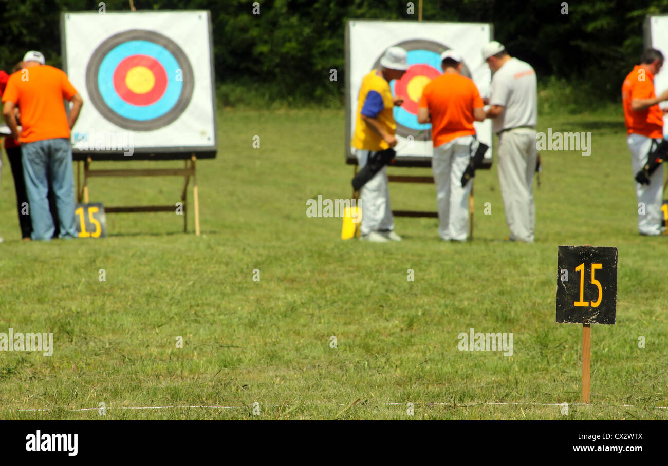 Archers on archery range are checking results in the background. Mark ...