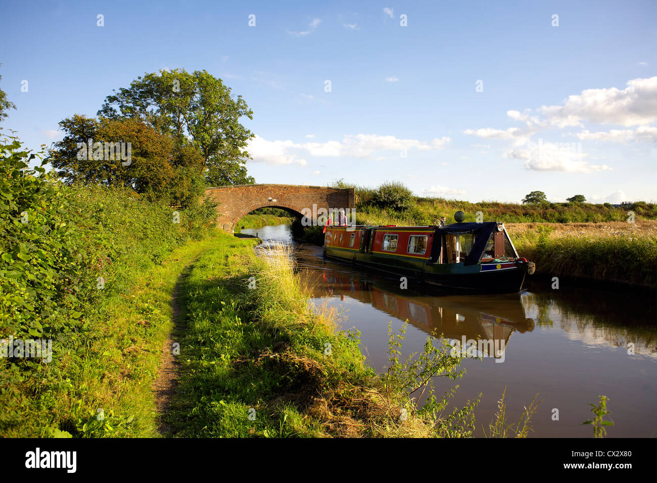 Colourful narrowboat cruising under Bridge 50 on the Coventry Canal ...
