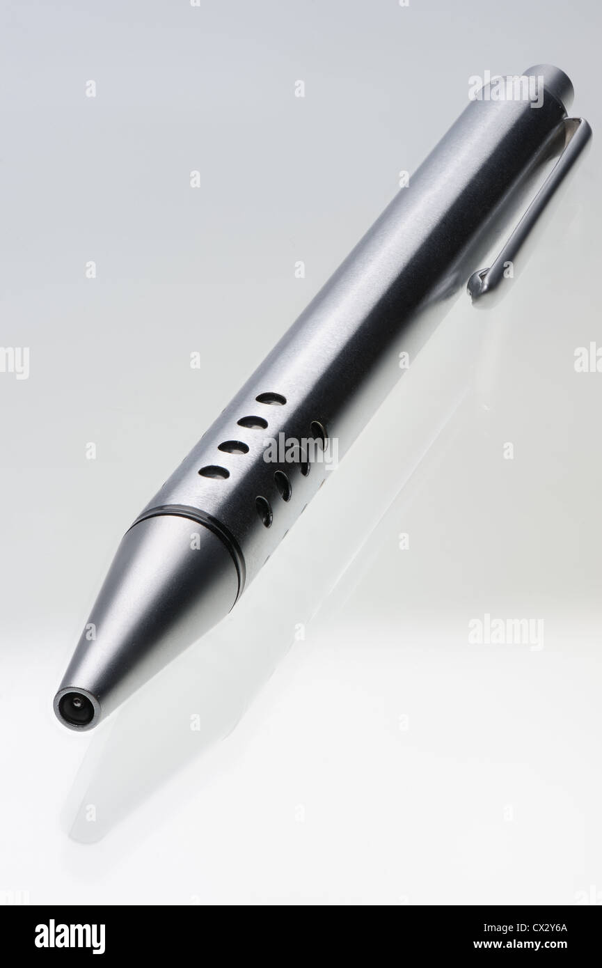 Shiny steel ball-point pen and its reflection in the glass surface ...