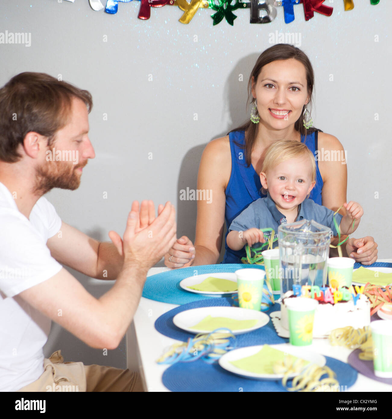 Child with parents during birthday party Stock Photo - Alamy