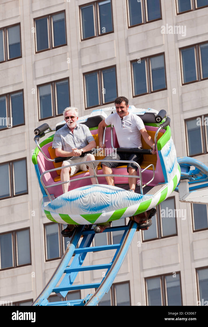 Two men in the cab of a roller coaster about to make a steep descent on ...