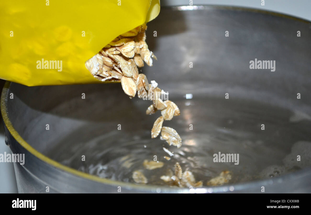 pouring oats into saucepan of water Stock Photo - Alamy
