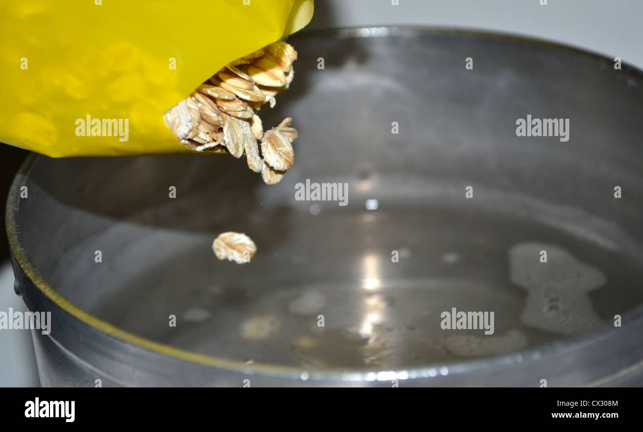 pouring oats into saucepan of water Stock Photo - Alamy