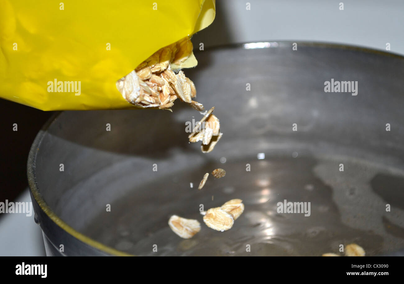 pouring oats into saucepan of water Stock Photo - Alamy