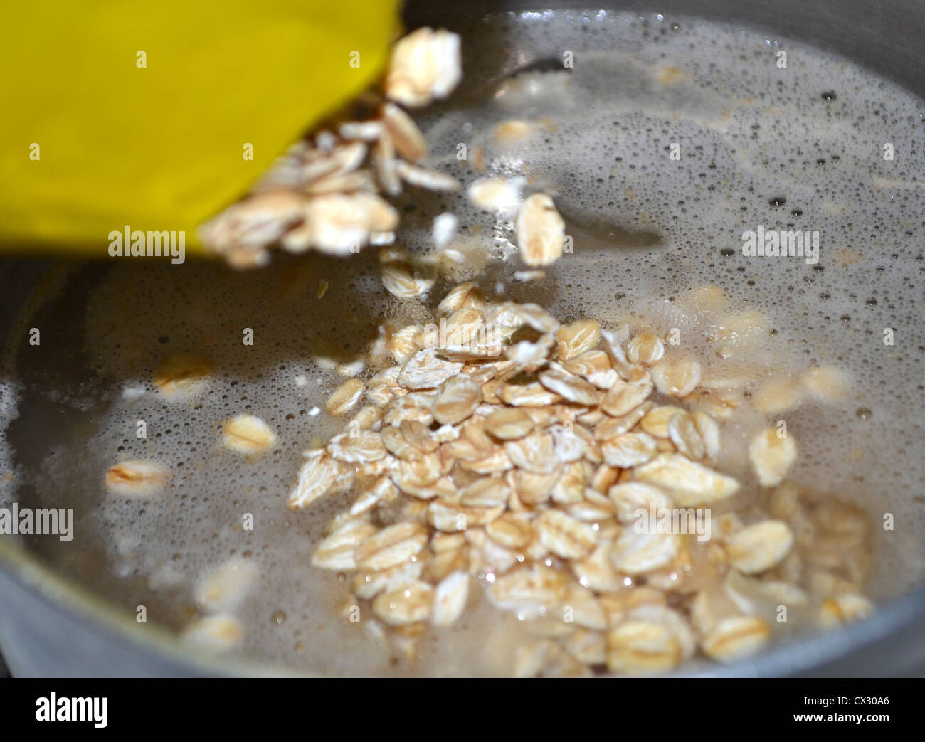 pouring oats into saucepan of water Stock Photo - Alamy