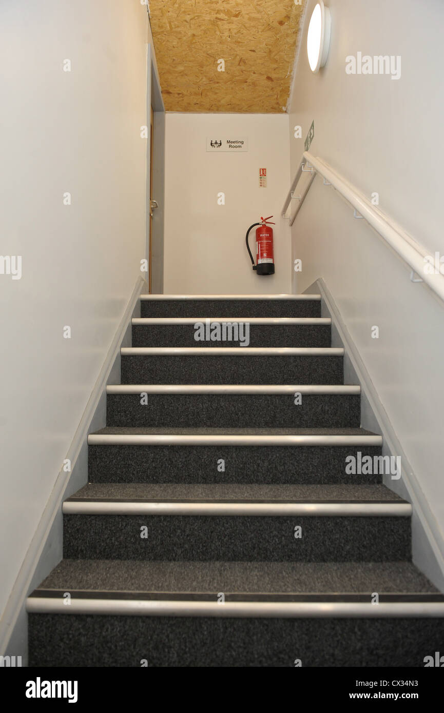 A view of a stairwell with fire extinguisher at the top of the stairs ...