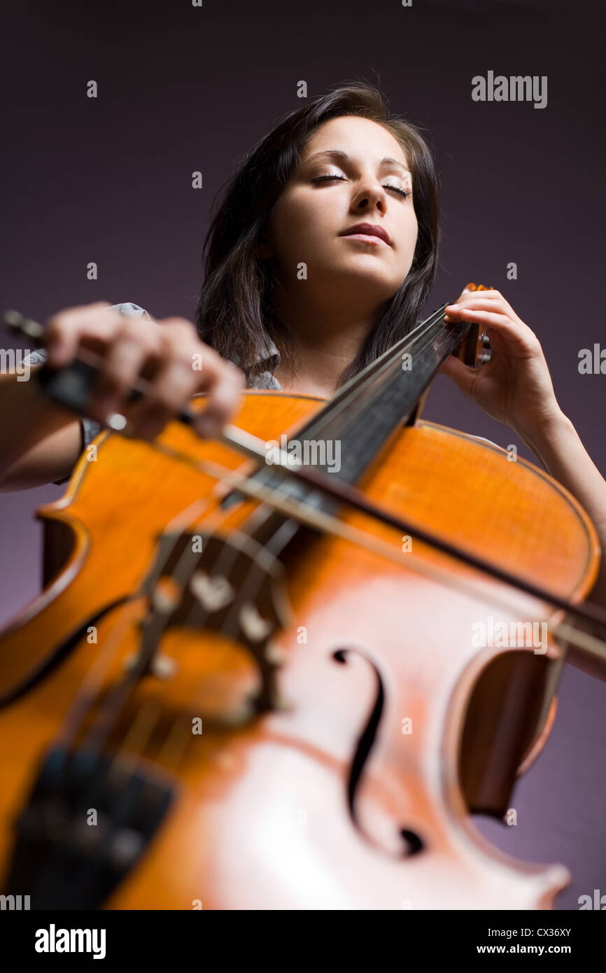 Portrait of beautiful young cellist immersed passionate in her music ...