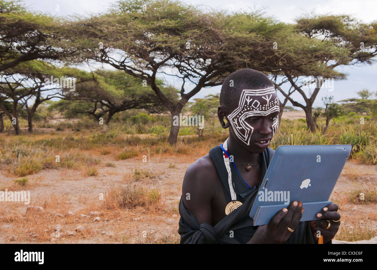 Tanzania Serengeti Africa Masai Maasai boy playing with I-pad computer ...
