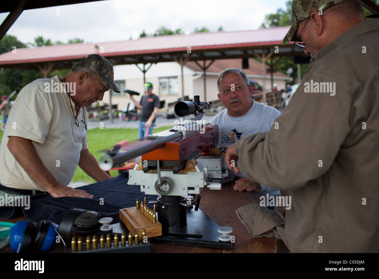 A benchrest shooter, left, adjusts his .30 caliber custom made rifle at ...