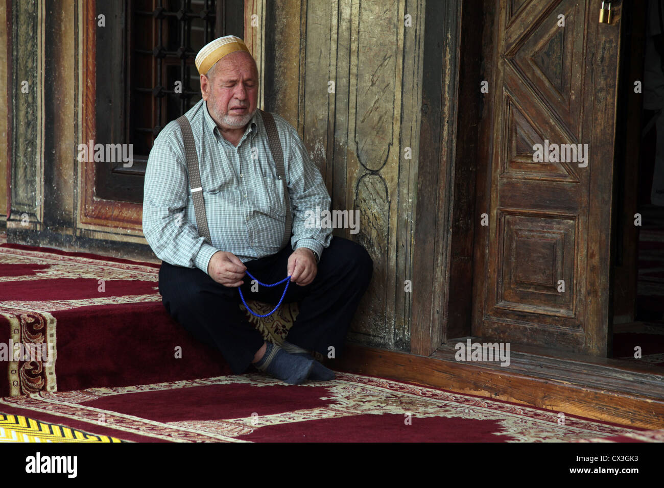 Muslim man seating in front Aladza painted mosque,Tetovo, Macedonia ...
