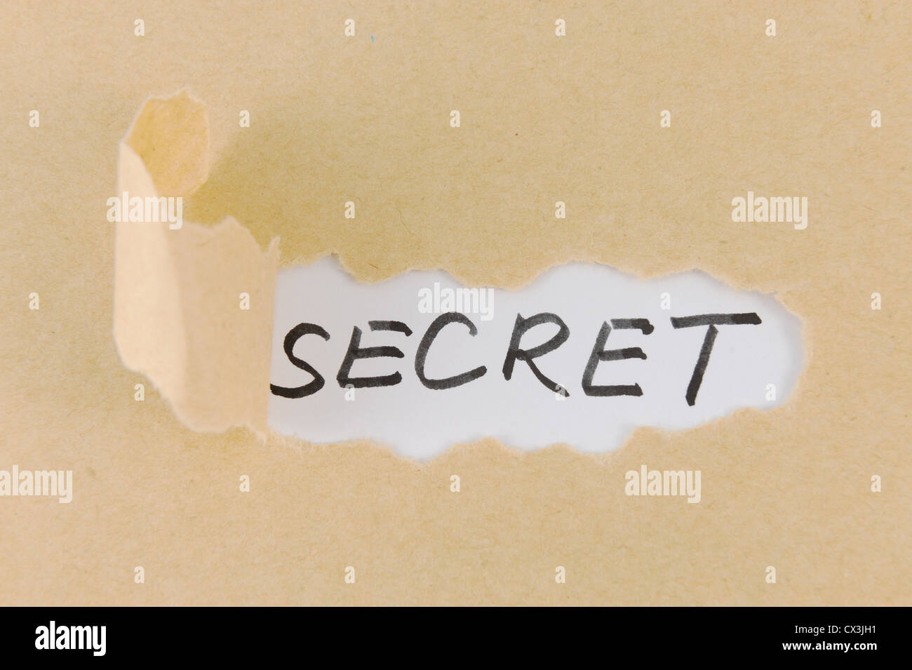 Torn paper with secret text behind it Stock Photo - Alamy